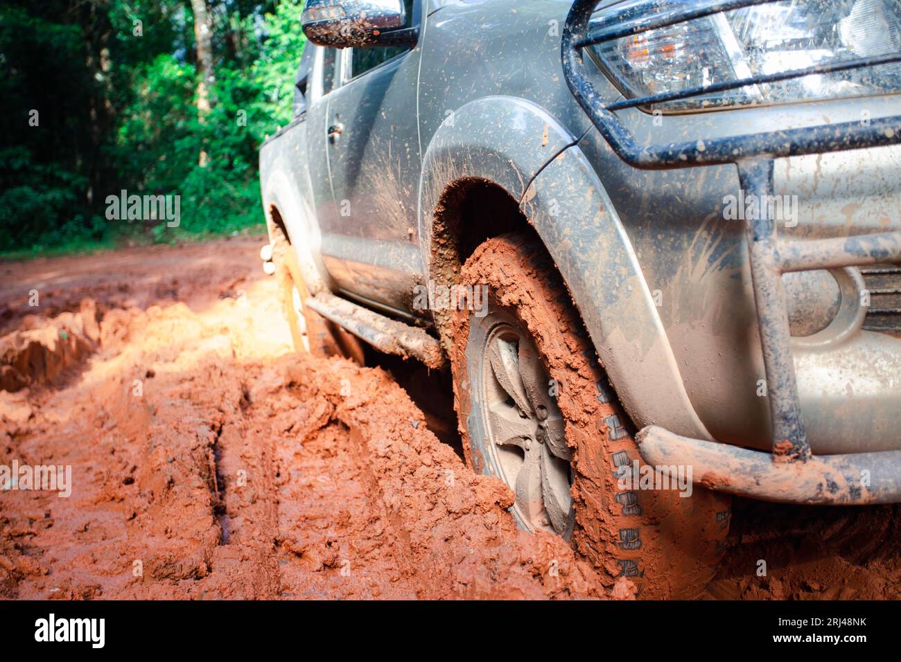 Off road cars on muddy road. Low angle view of front of SUV on mountain ...