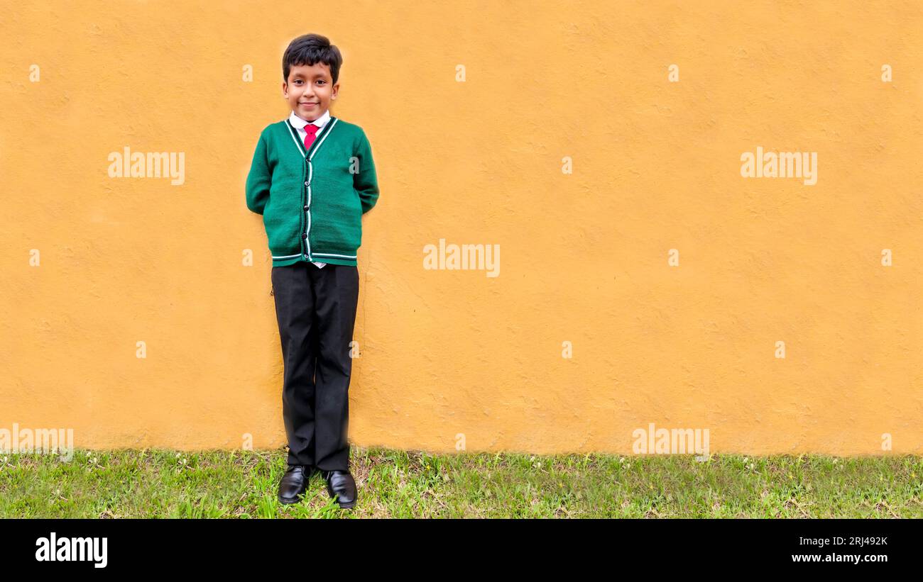Dark-haired 9-year-old Latino boy in a public school uniform is excited ...
