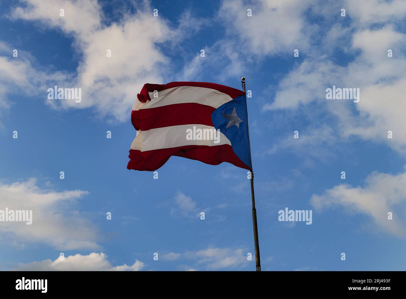 A vibrant American flag waving against a beautiful blue sky backdrop ...
