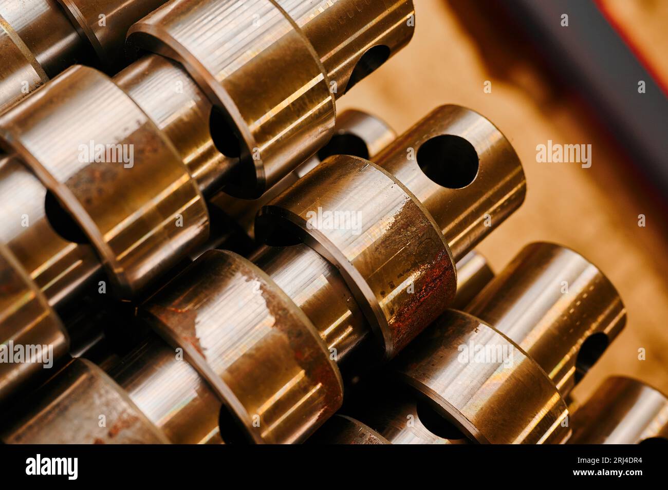 Stacks of steel rollers with holes in plant warehouse Stock Photo - Alamy