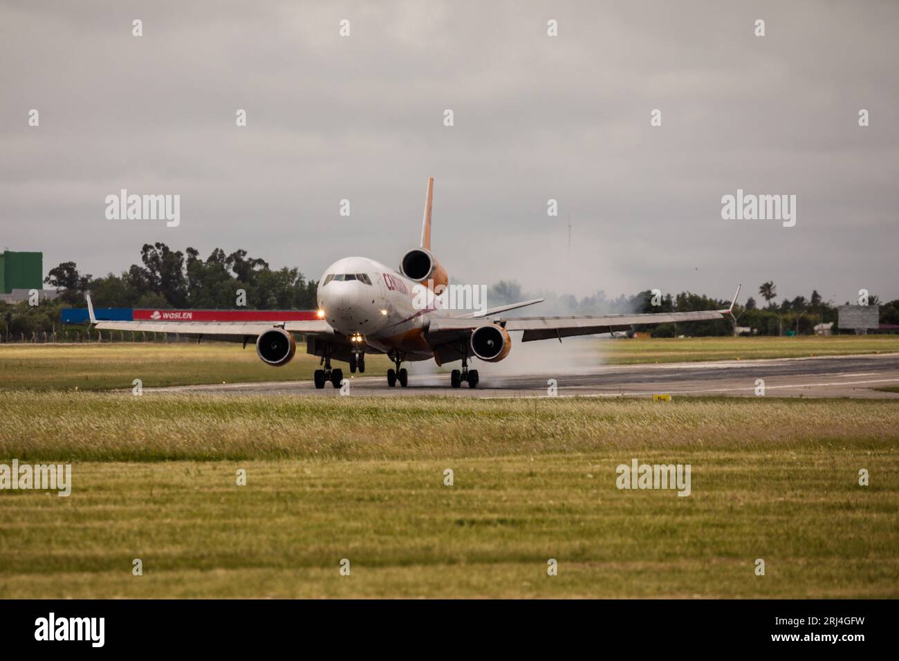 An airplane in mid-flight with its landing gear extended and wheels ...