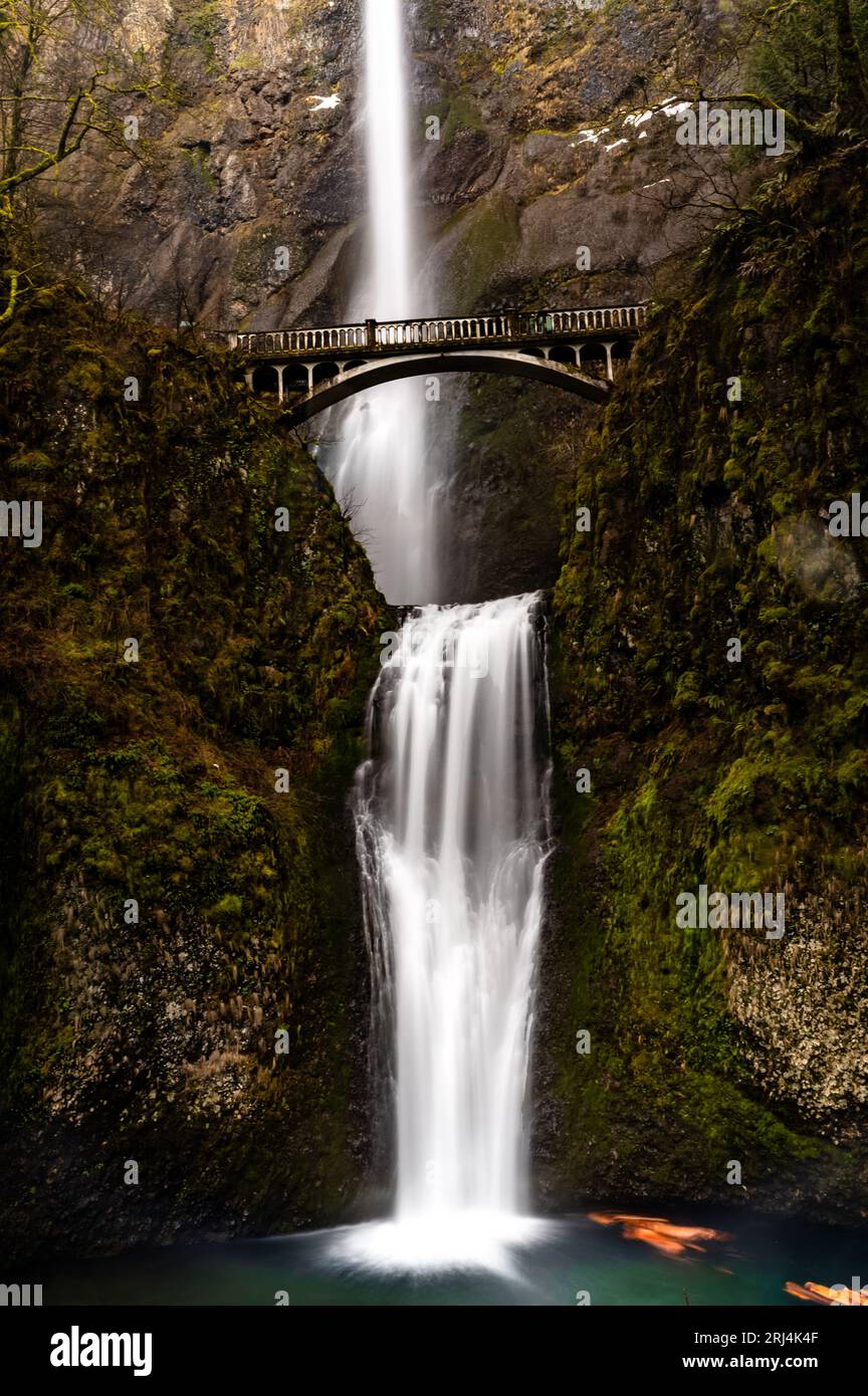 An awe-inspiring waterfall cascading down a lush moss-covered rocky ...