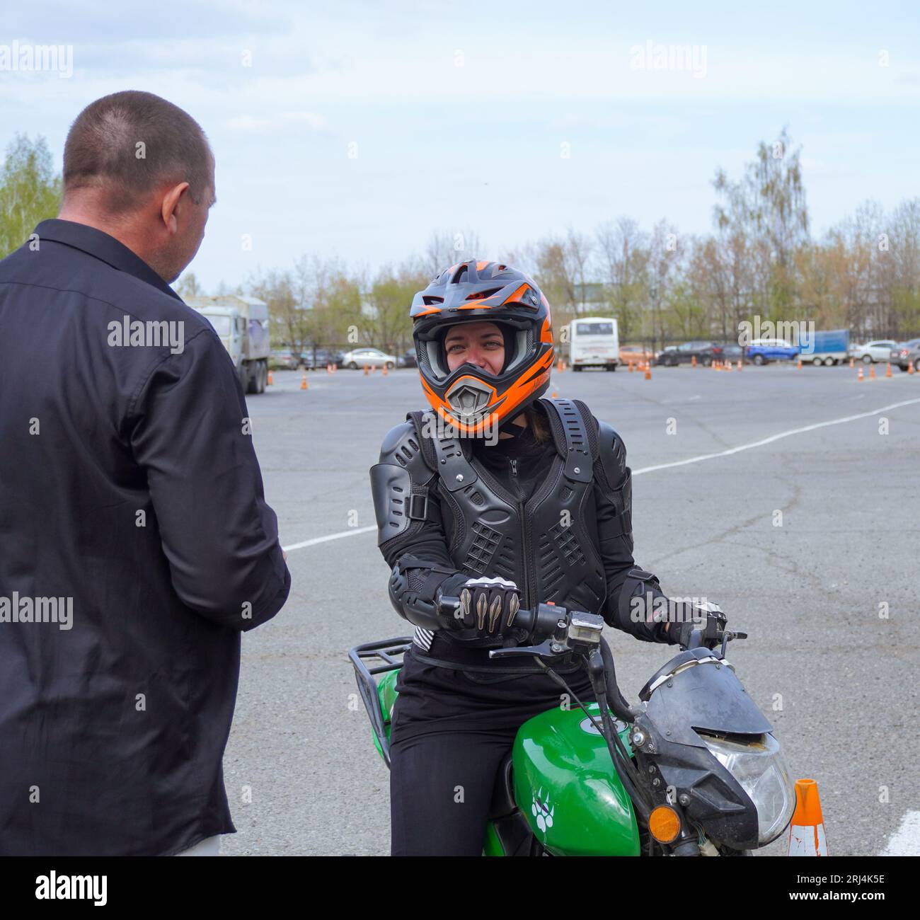 A young woman is learning to ride a motorbike in a motorcycle school ...