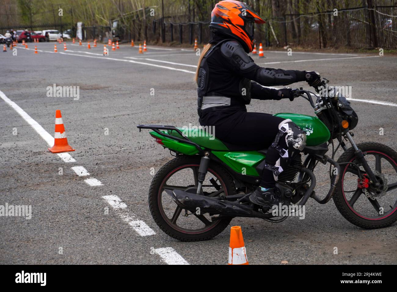 A young woman is learning to ride a motorbike in a motorcycle school ...