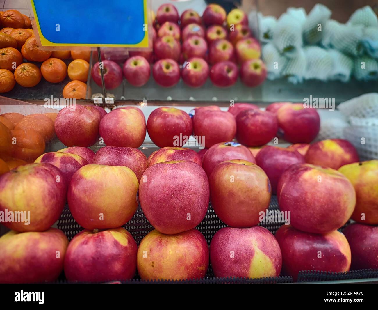 Red apples are arranged in the display shelf in a supermarket. Business ...