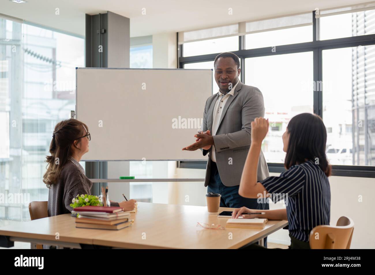 A professional African American businessman or male boss training Asian ...