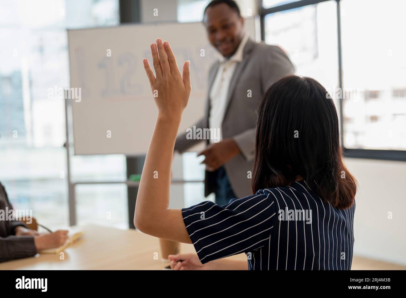 Close-up image of an Asian businesswoman raising her hand during the ...