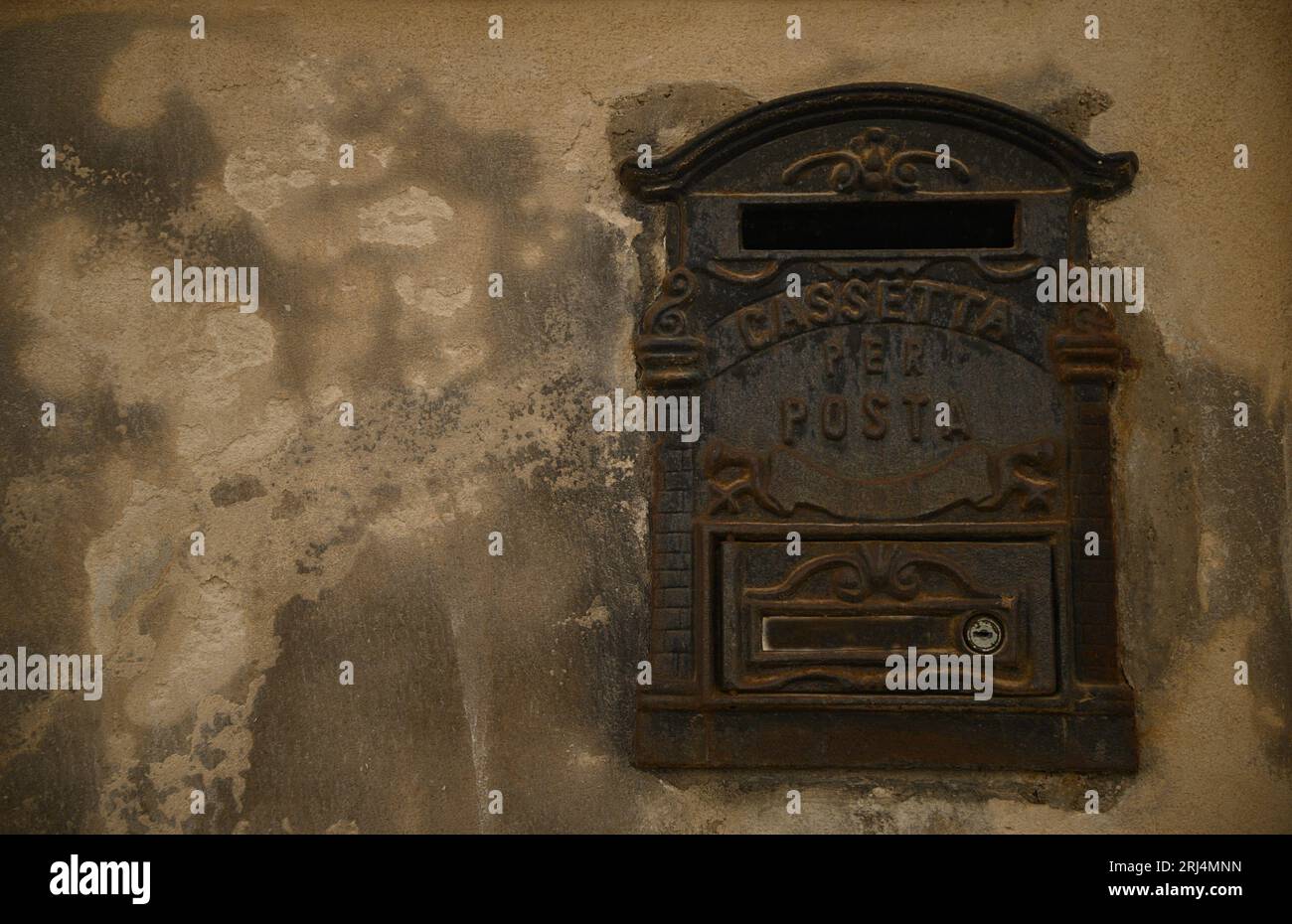Antique cast iron mailbox with Italian letters against a weathered ...