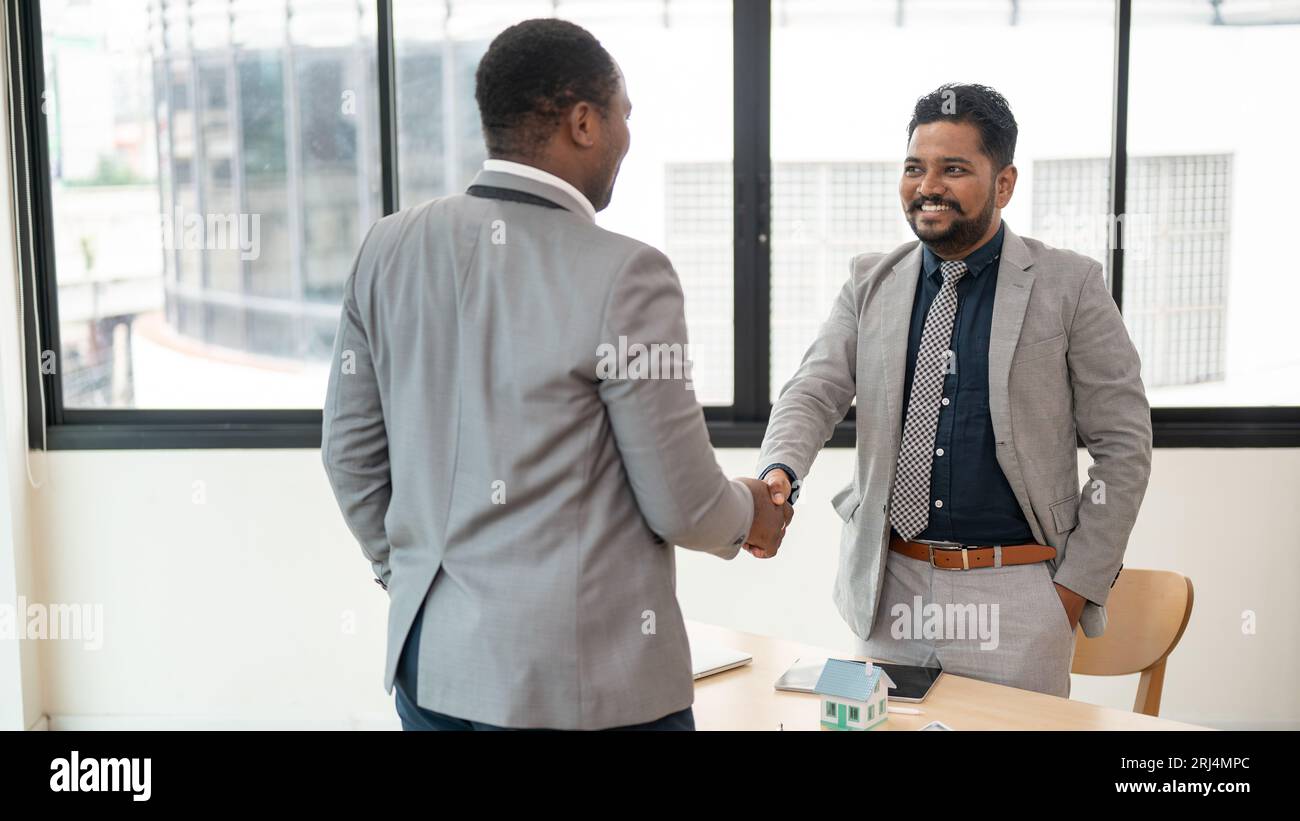 A professional and smiling Indian-Asian businessman shakes hands with ...