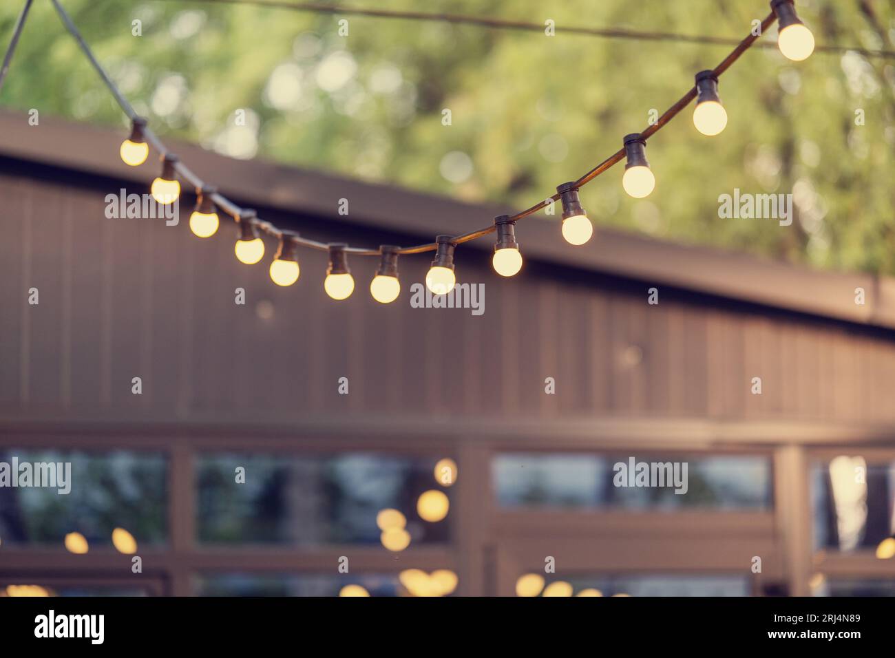 A row of lamps in the interior of a street cafe. Lighting fixtures as ...