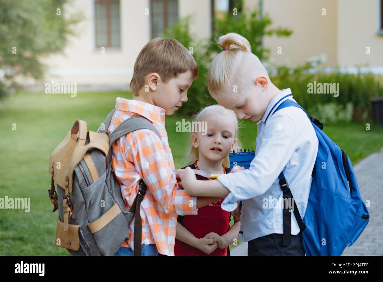 children walking from school with backpacks on sunny day having fun ...