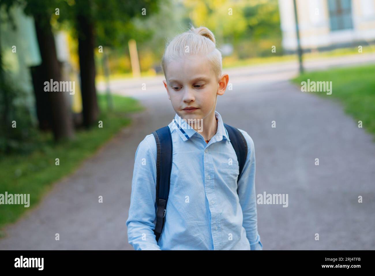 caucasian boy walking from school wearing school bag. Begining of ...