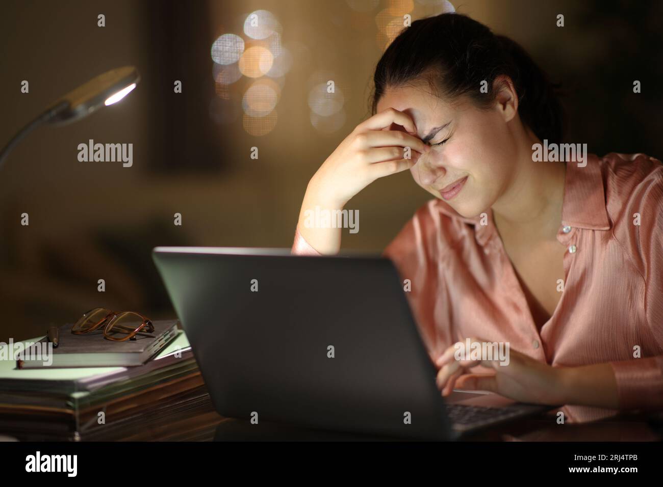Teleworker suffering eyestrain working in the night at home Stock Photo ...