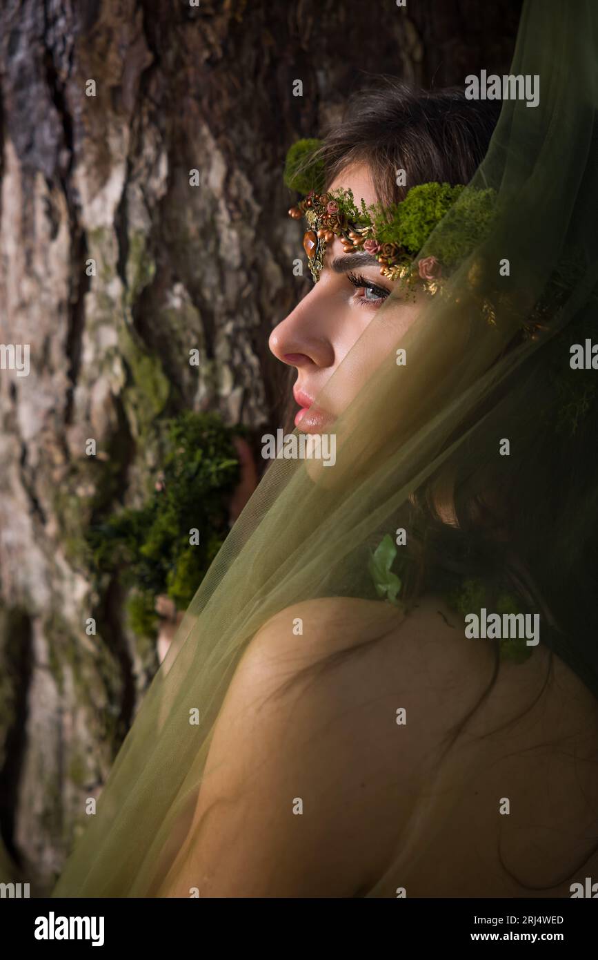 Beautiful young woman in green dress posing as a forest fairy with ...