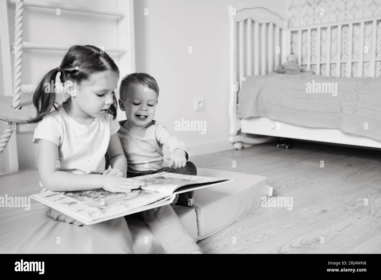 cute little boy and a boy reading book in their child room. floor by ...