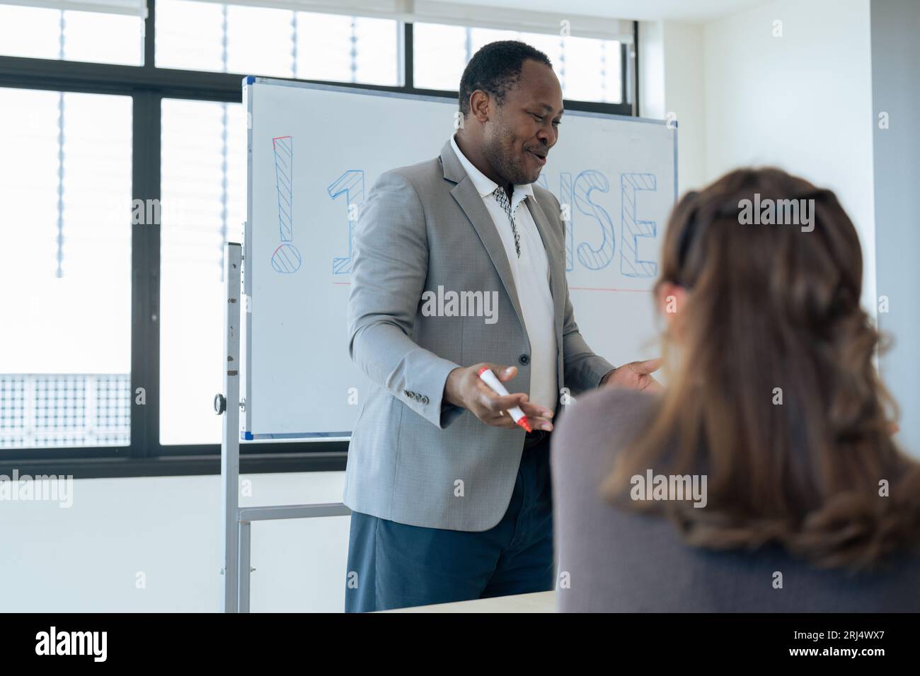 An African American mature professor with classmates in computer lab ...