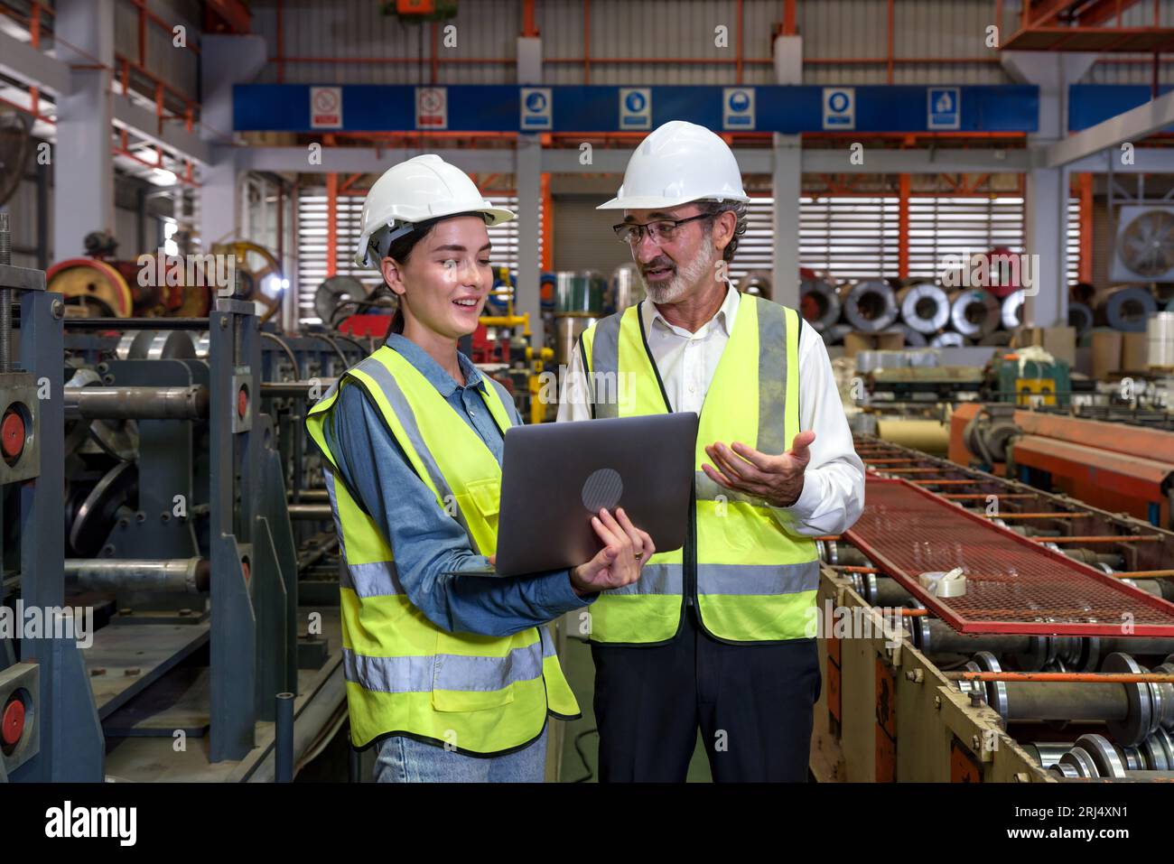 Two dedicated engineers dressed in safety gear, engrossed in their ...