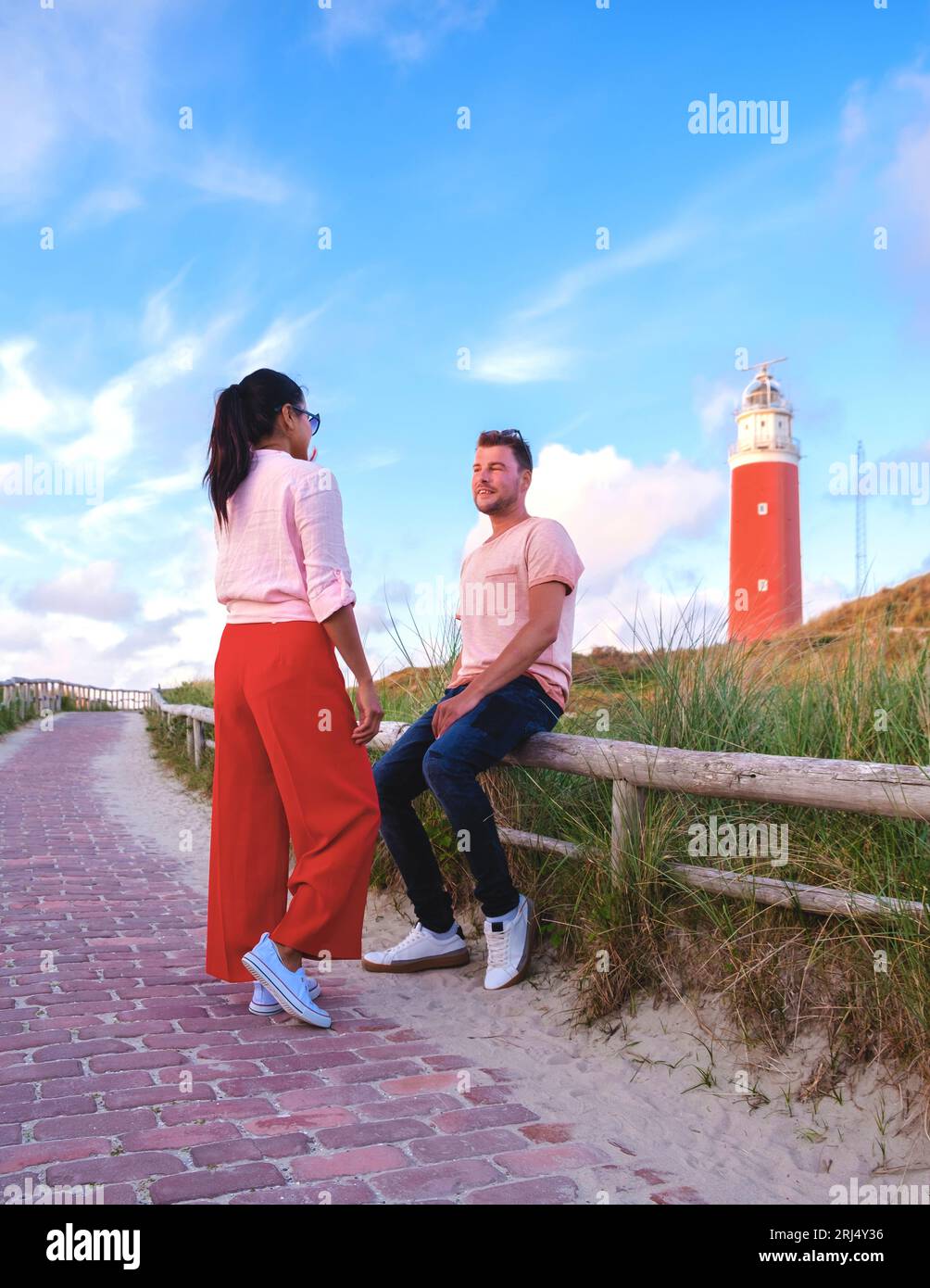 A couple visit Texel lighthouse during sunset Netherlands Dutch Island ...