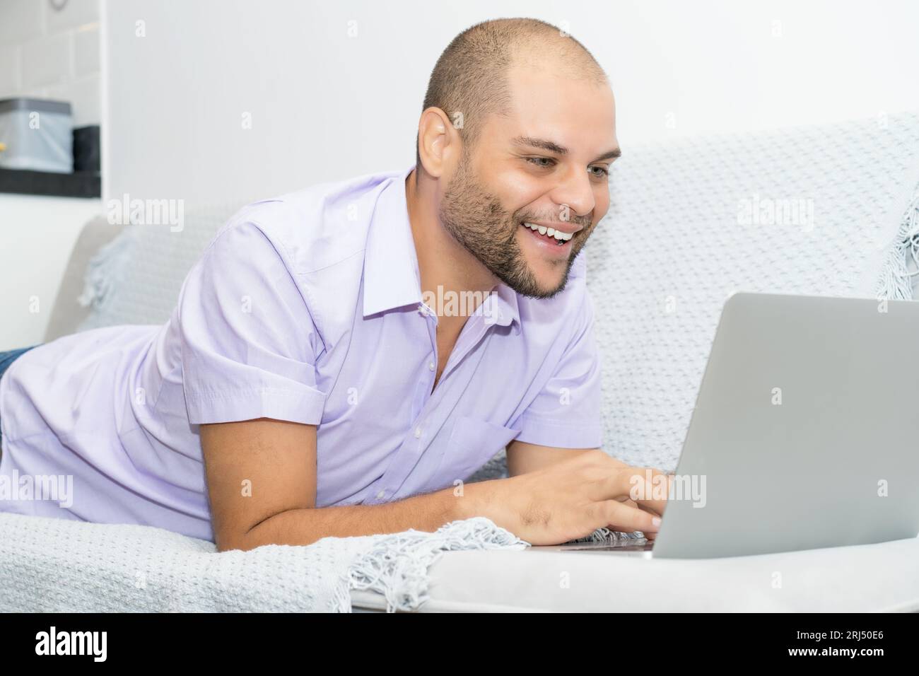 Laughing man with bald and beard working at computer indoors at home at ...