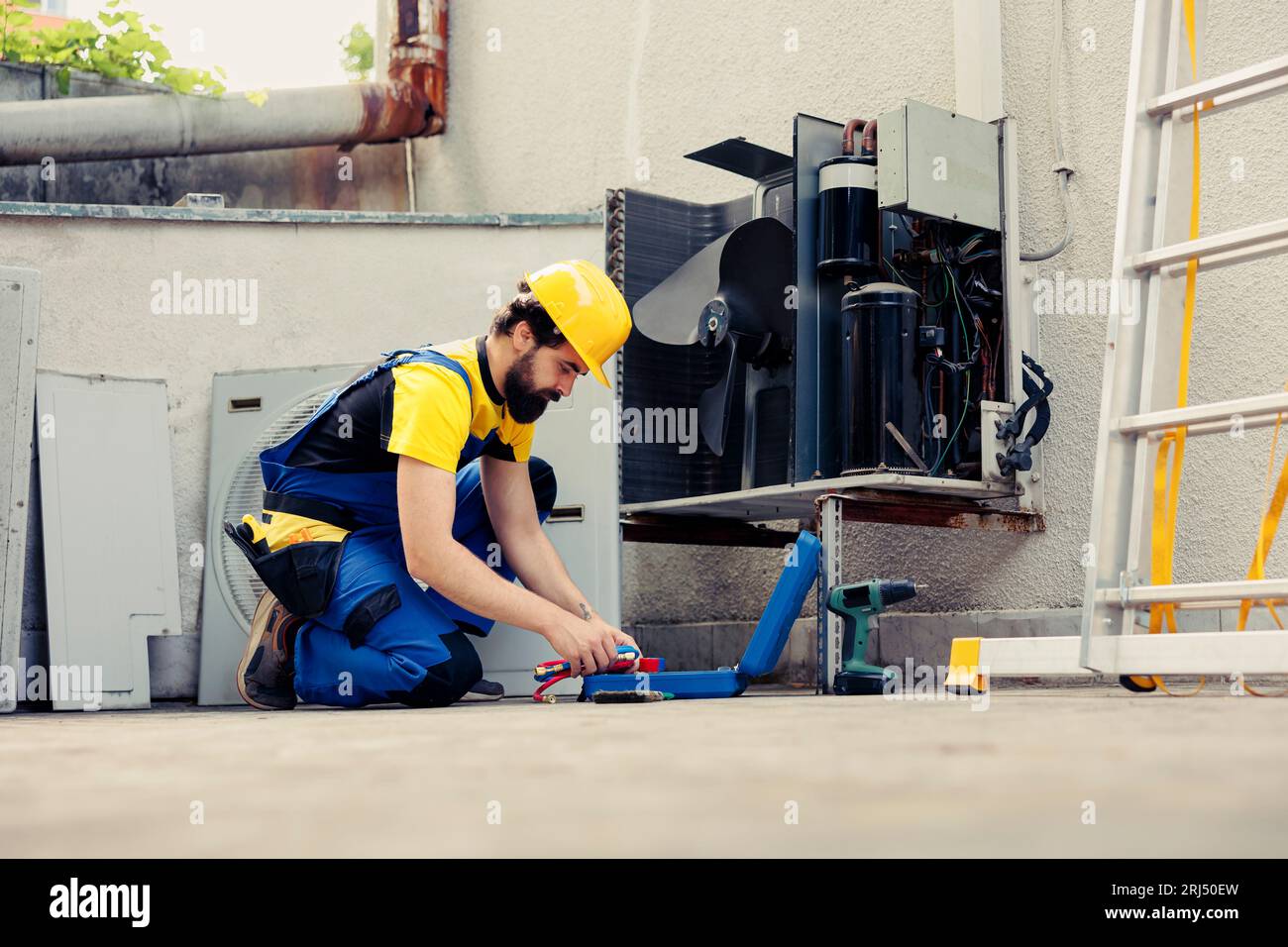 Skilled repairman starting annual routine maintenance on outdoor air ...