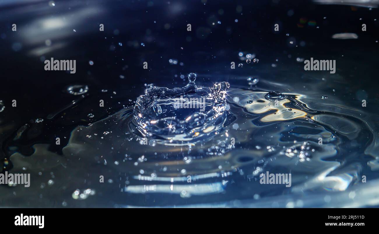 Clear aqua water droplet splashing in concentric circles, capturing ...