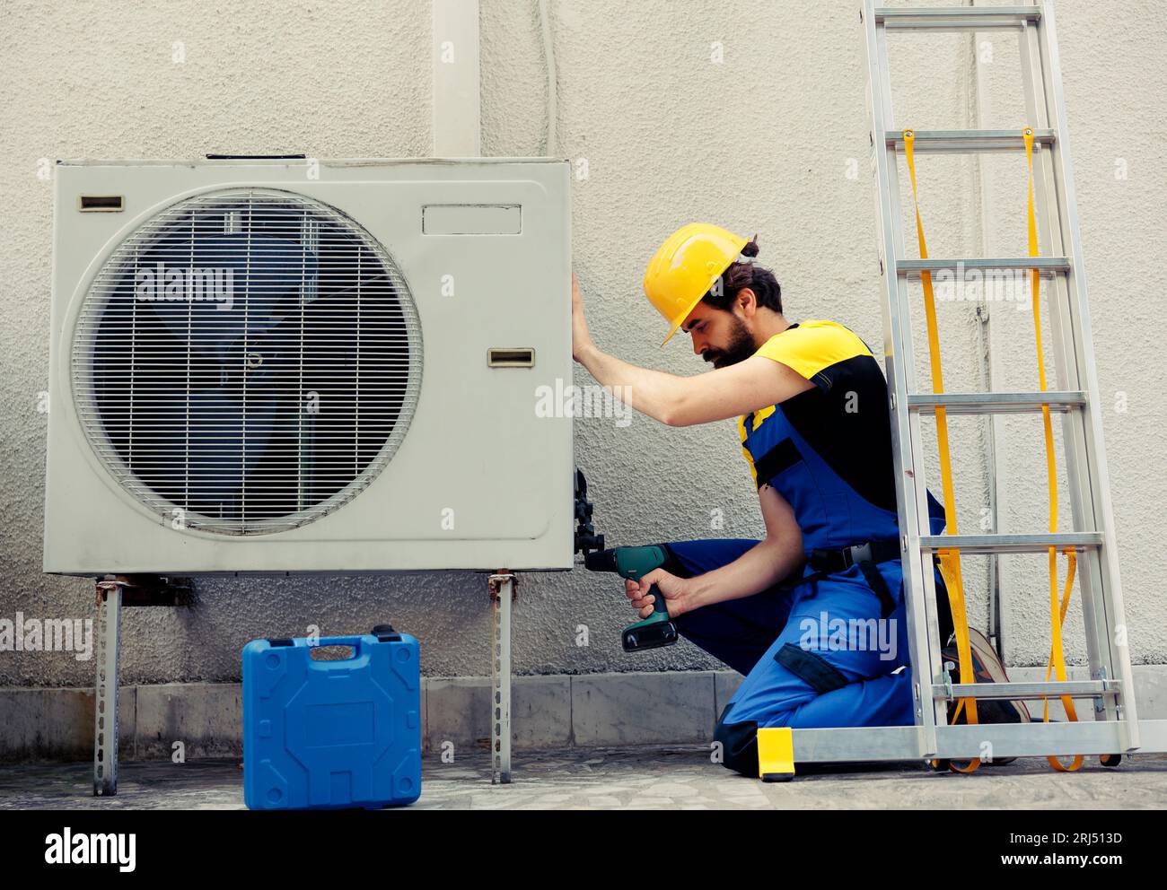 Competent repairman starting work on defective air conditioner, using ...