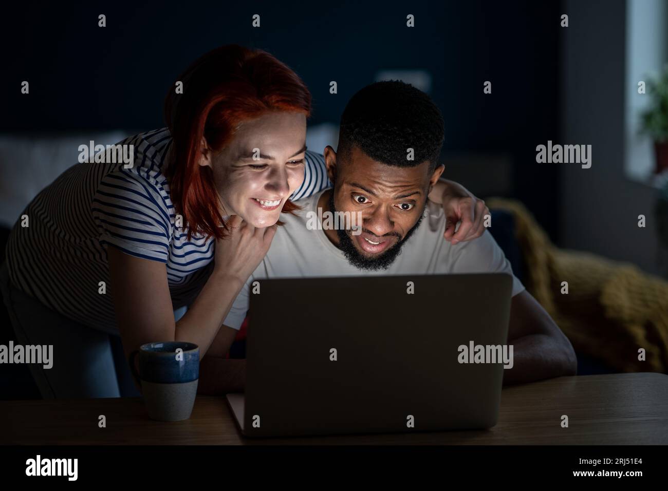 Happy romantic couple watching videos on Internet from laptop laugh ...
