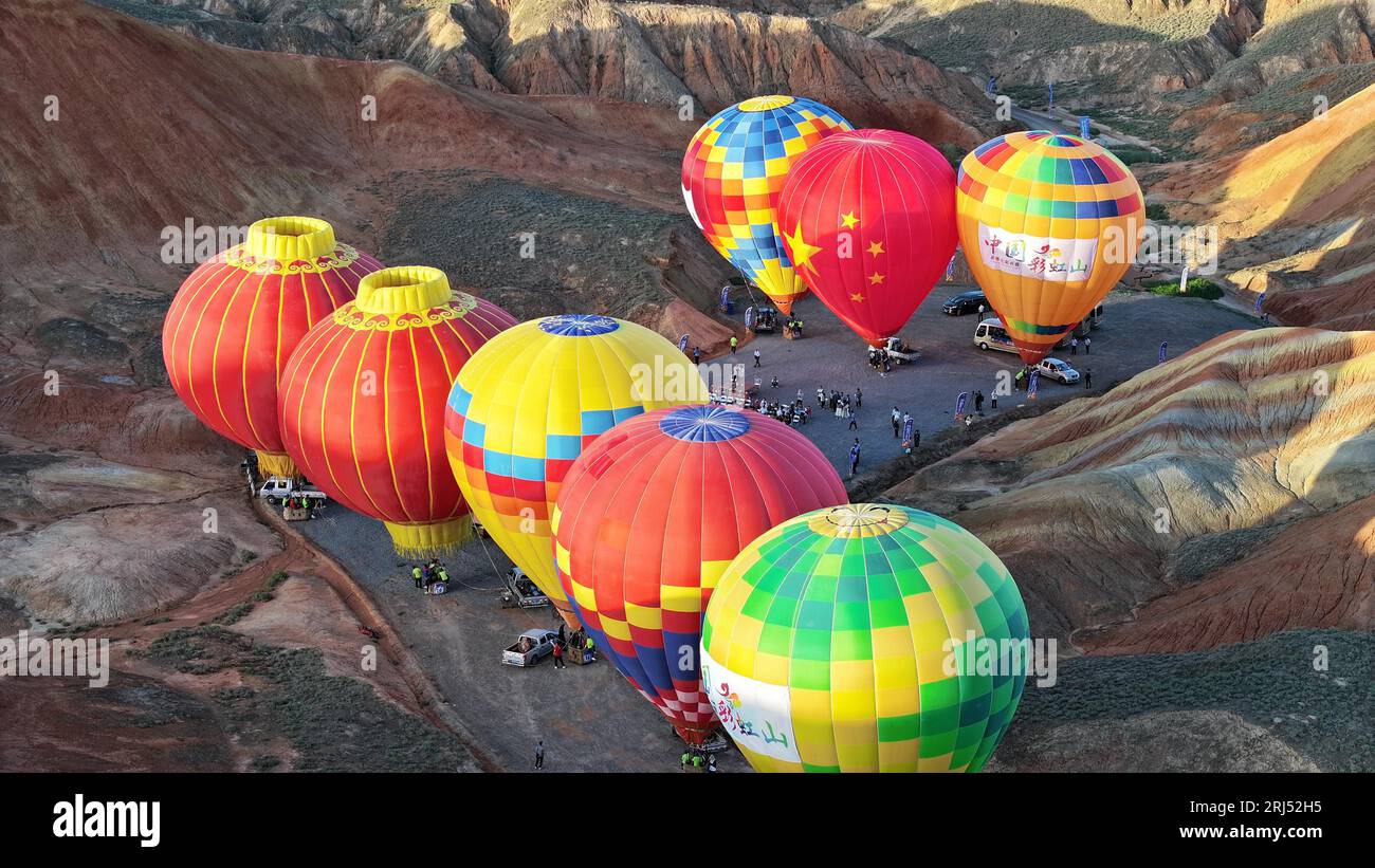 Colorful hot air balloons glide across the Qicai Danxia scenic area in ...