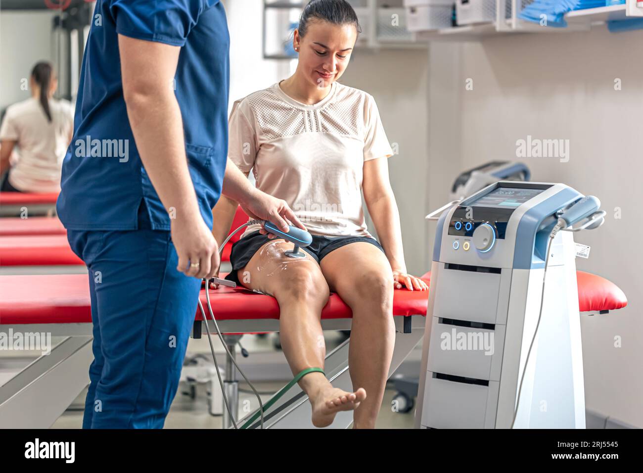 Doctor using machine to treat the knee joints of a patient Stock Photo ...