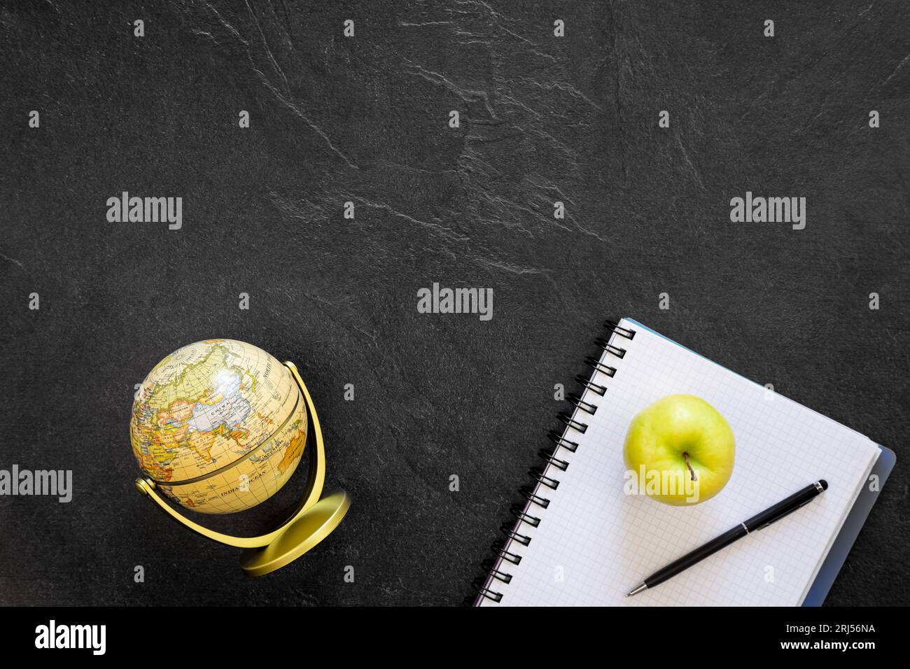 Globe, notepad and apple on black background, top view Stock Photo - Alamy