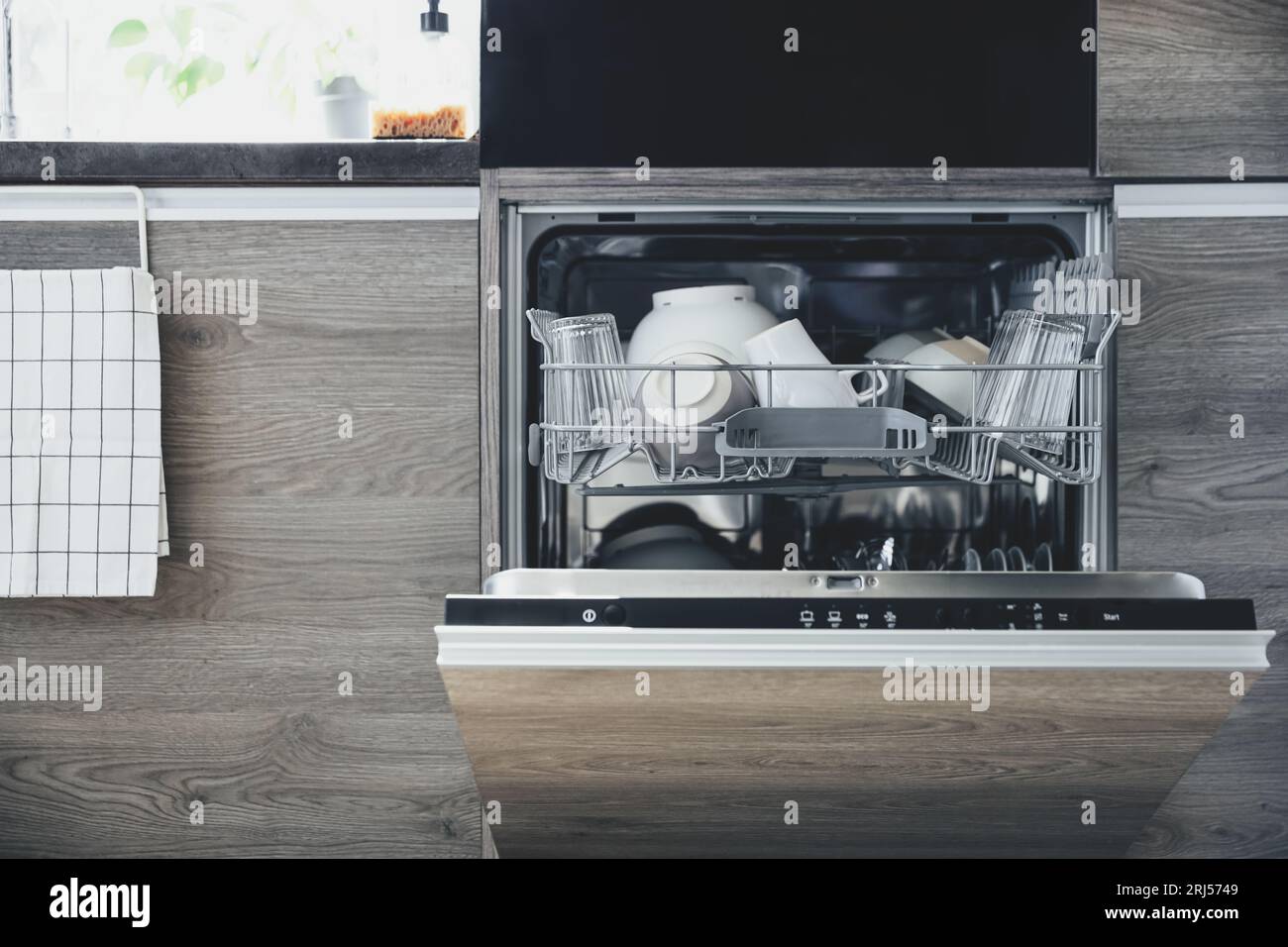 Closeup of opened automatic stainless built-in dishwasher machine ...