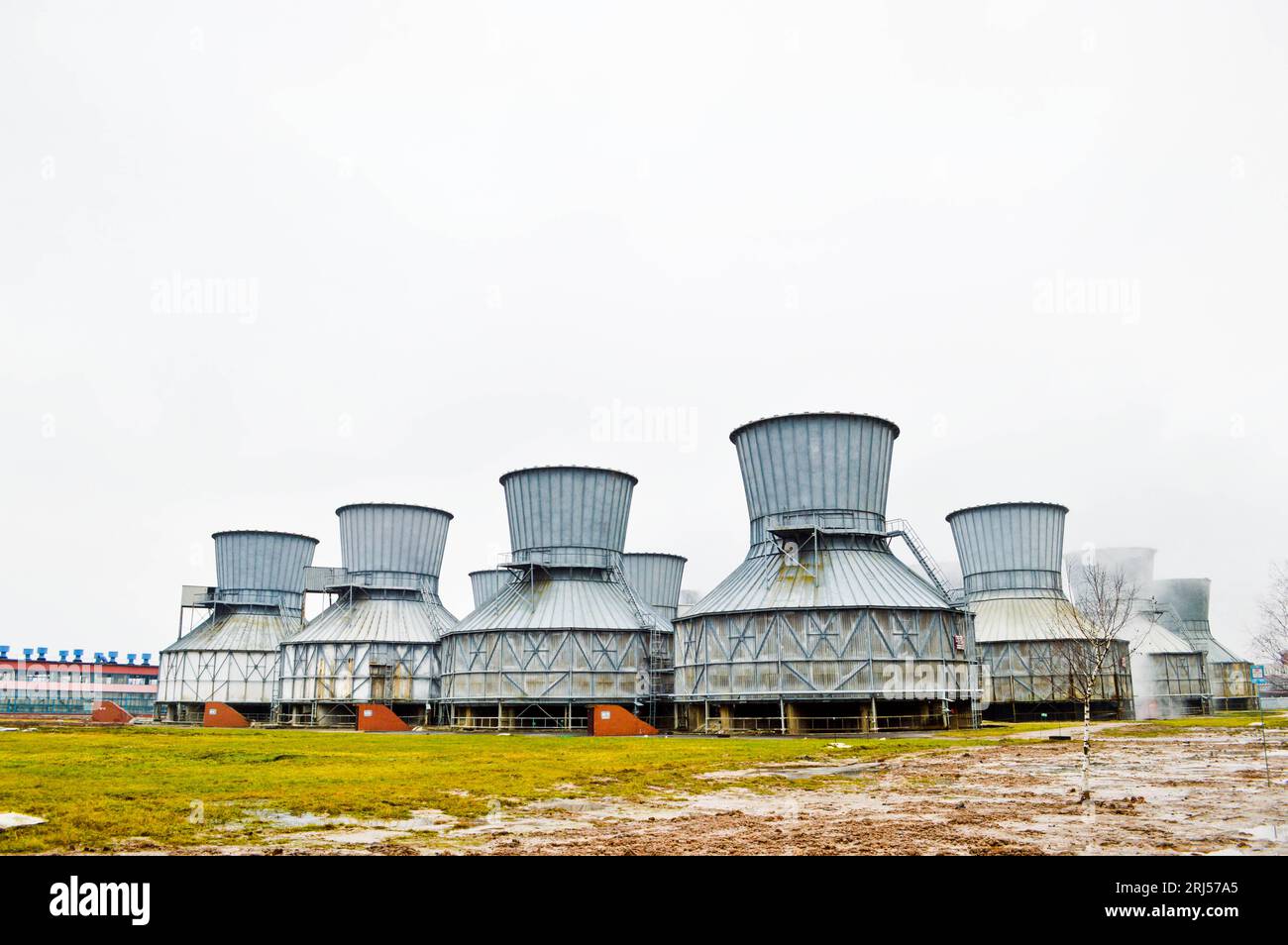 Large cooling towers in water and fog at an oil refinery, petrochemical ...