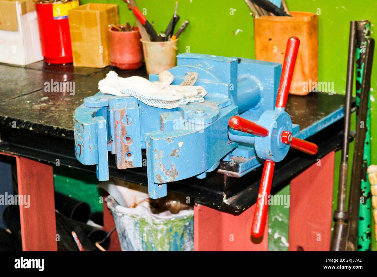 Blue iron metal large industrial vice and working gloves in the ...