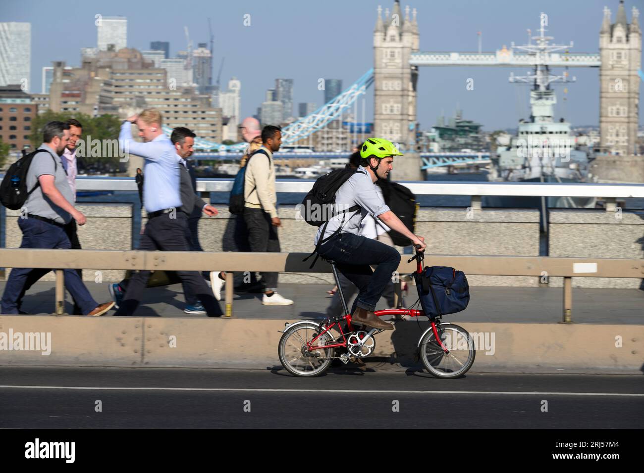 A man cycling Brompton folding bicycle during the evening rush hour ...