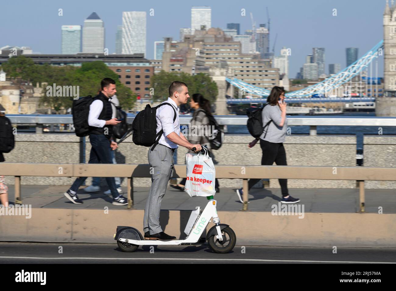 A man riding on a Lime e-scooter part of the Transport for London e-scooter hire scheme, London ...
