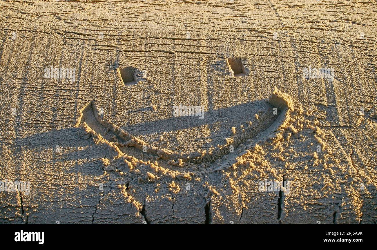 Very simple Smiley face drawn in smoothed bank of builders' sand. Low ...