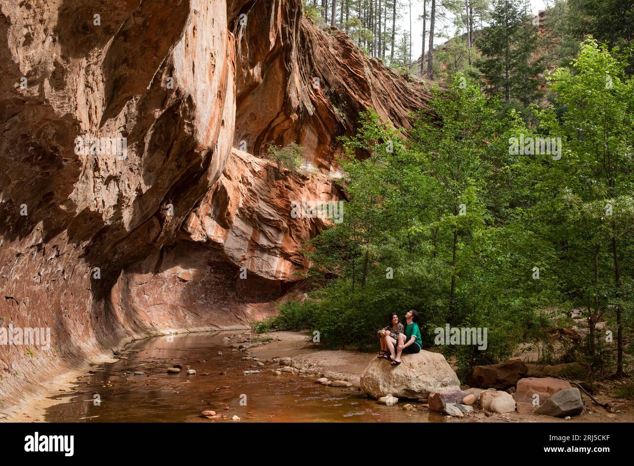 Couple sit on rocky ledge hi-res stock photography and images - Alamy