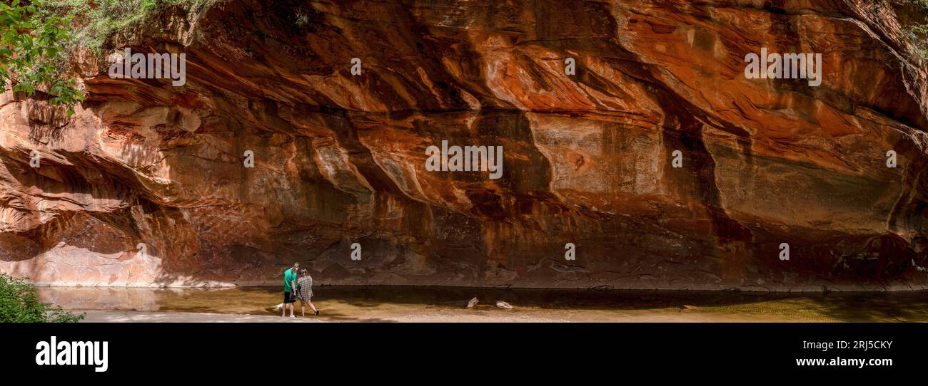 Panorama of young couple under large rock ledge Stock Photo - Alamy