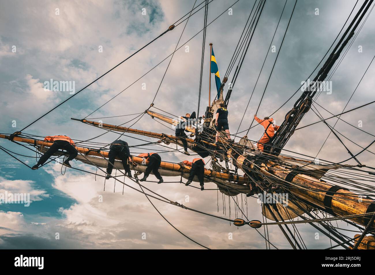 A group of people standing on the deck of a traditional sailing vessel ...