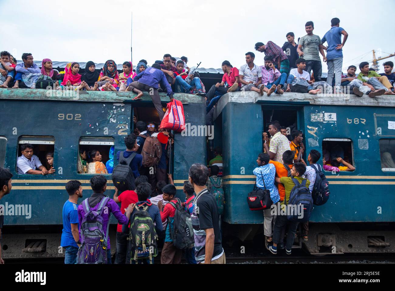 Home-bound people struggle to get the rooftop of a train at Airport ...