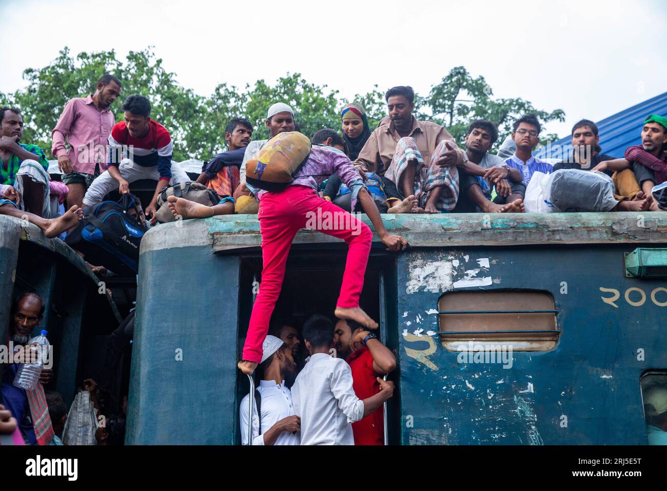 Home-bound people struggle to get the rooftop of a train at Airport ...