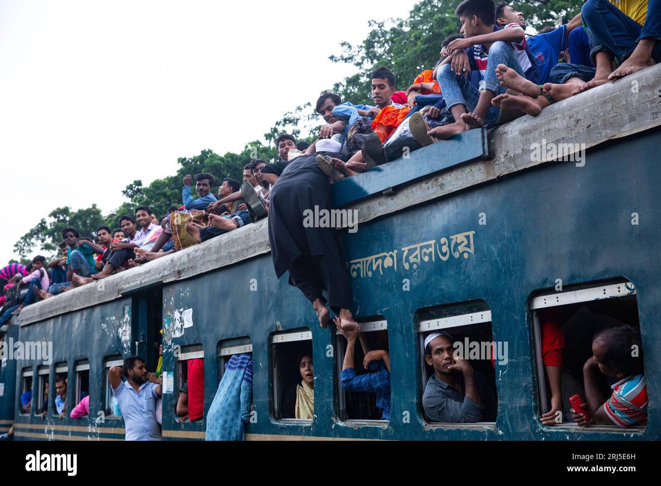 Home-bound people struggle to get the rooftop of a train at Airport ...
