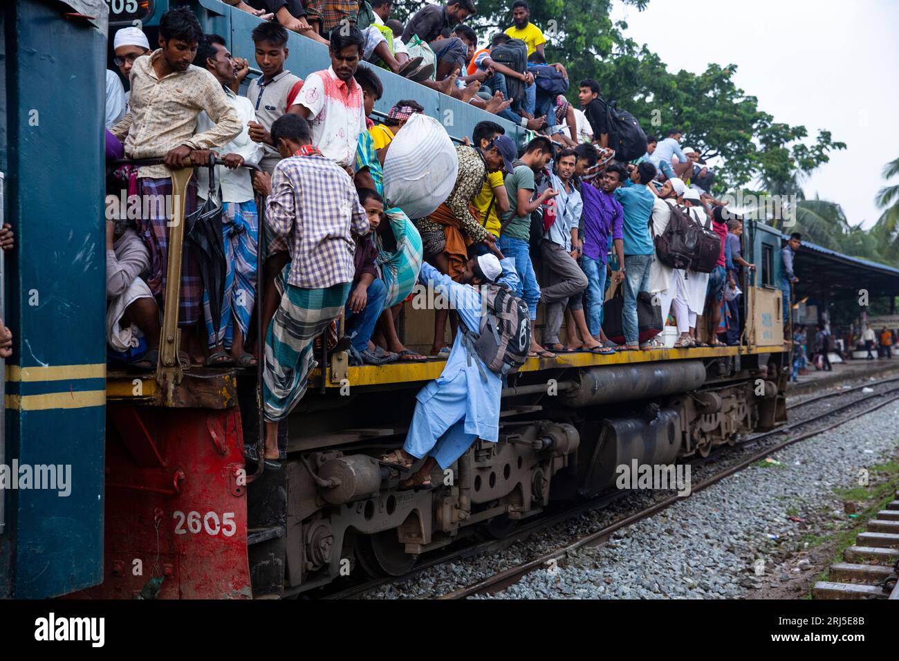 Home-bound people struggle to get the rooftop of a train at Airport ...