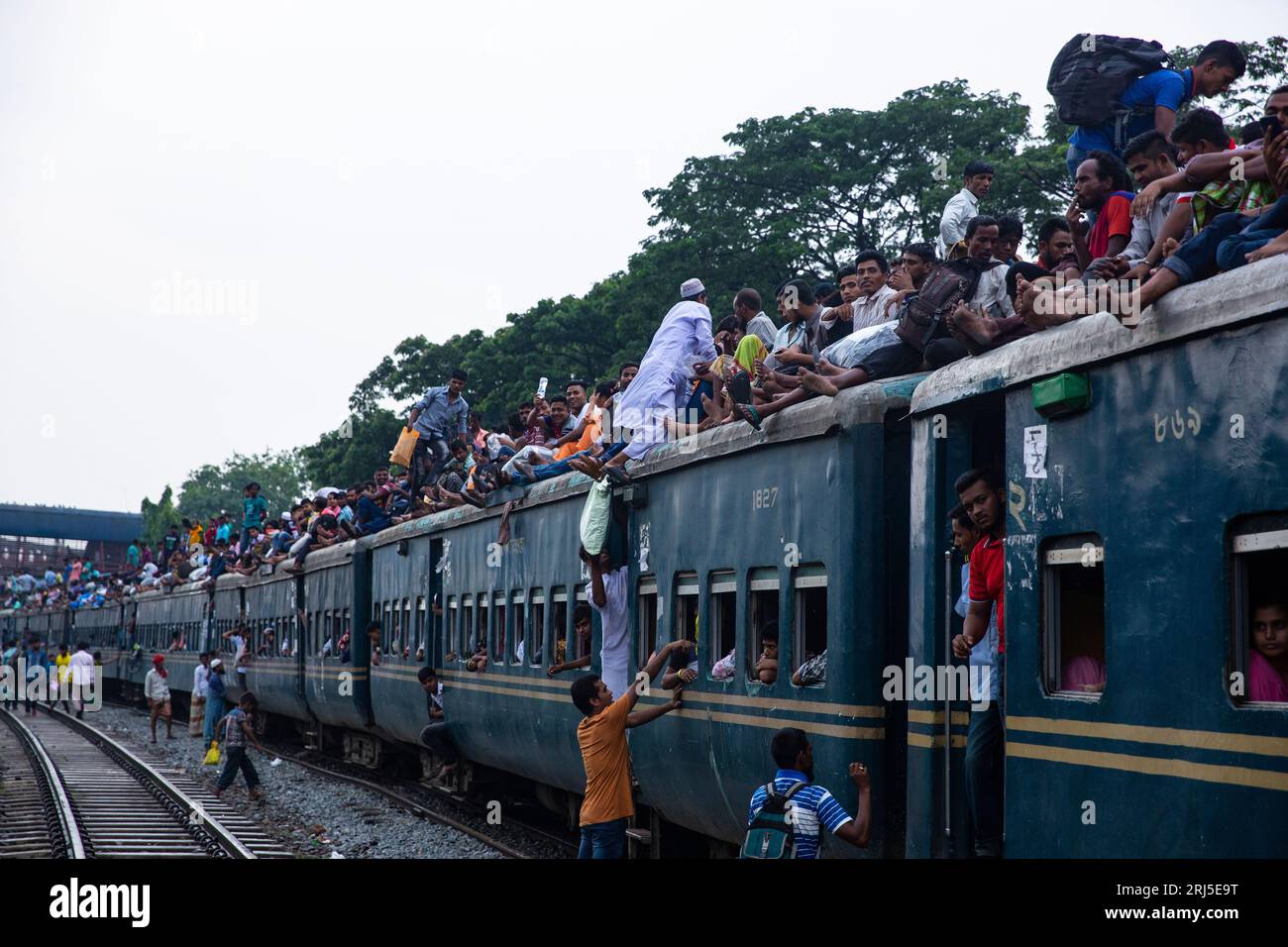 Home-bound people struggle to get the rooftop of a train at Airport ...