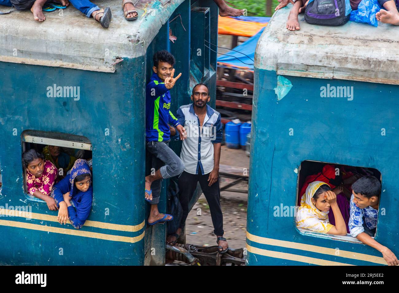 Low-income people travel in between two compartments of a local train ...