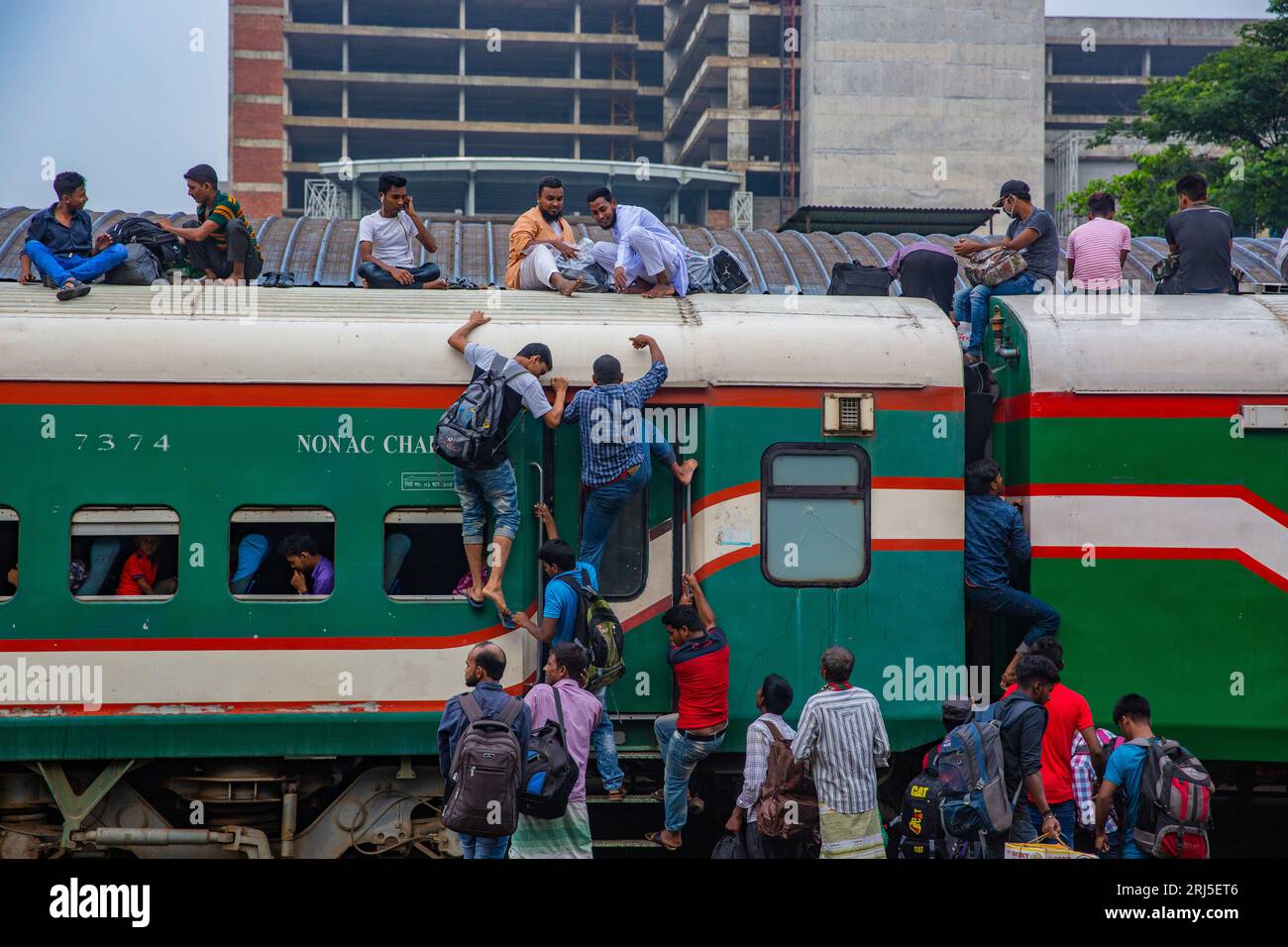 Home-bound people struggle to get the rooftop of a train at Airport ...