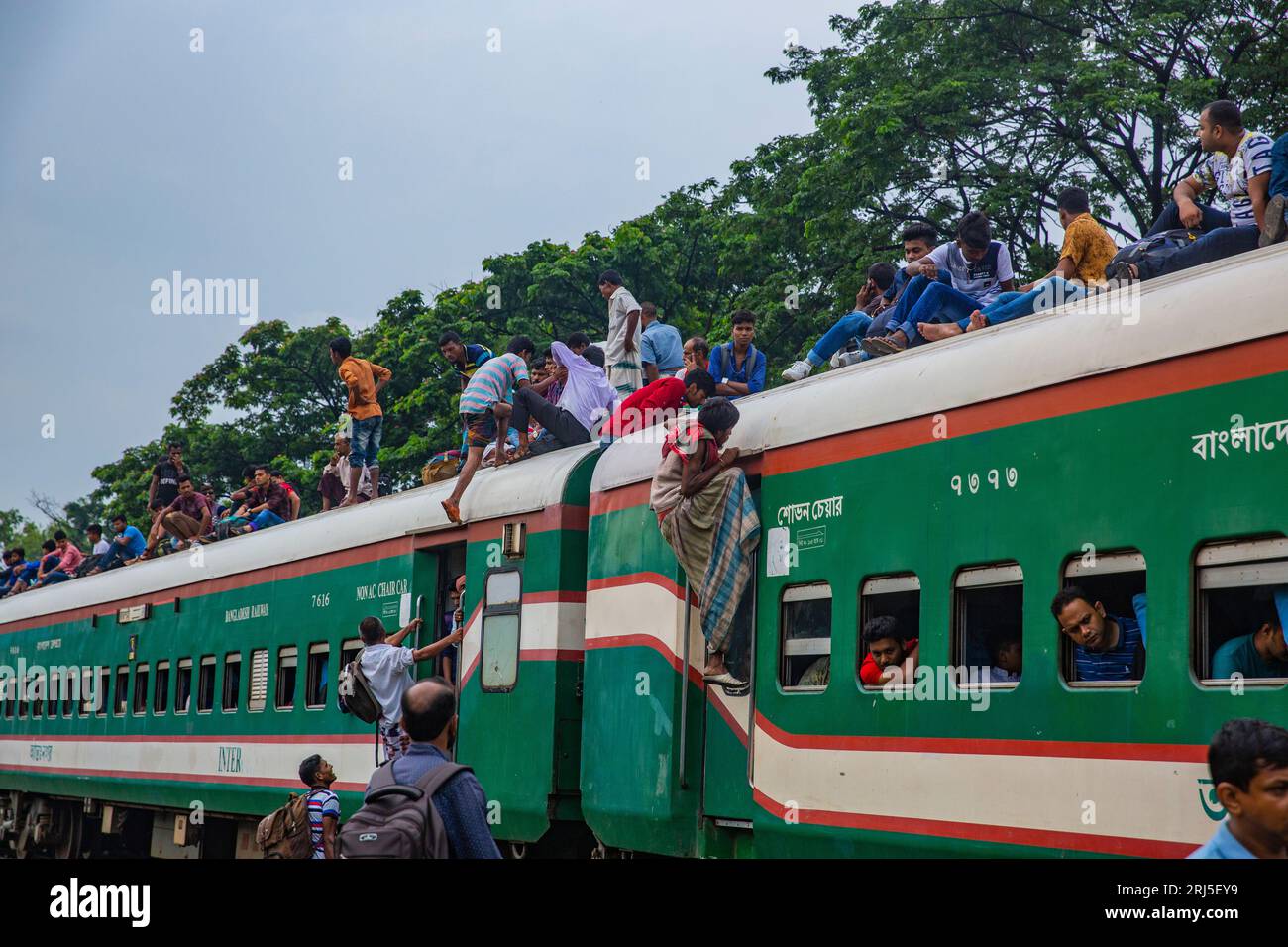 Home-bound people struggle to get the rooftop of a train at Airport ...