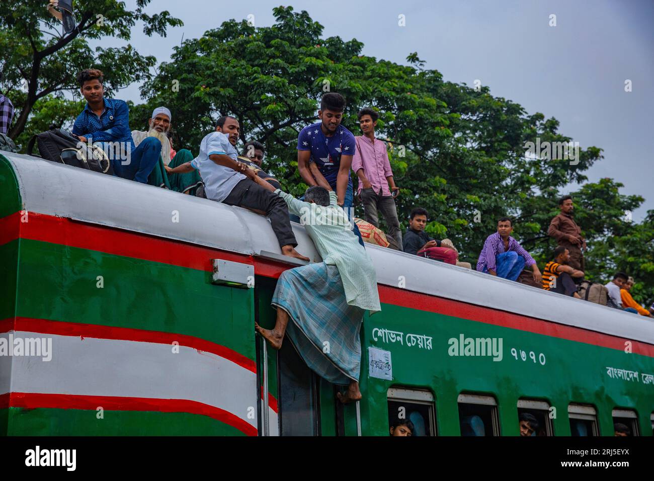 Home-bound people struggle to get the rooftop of a train at Airport ...