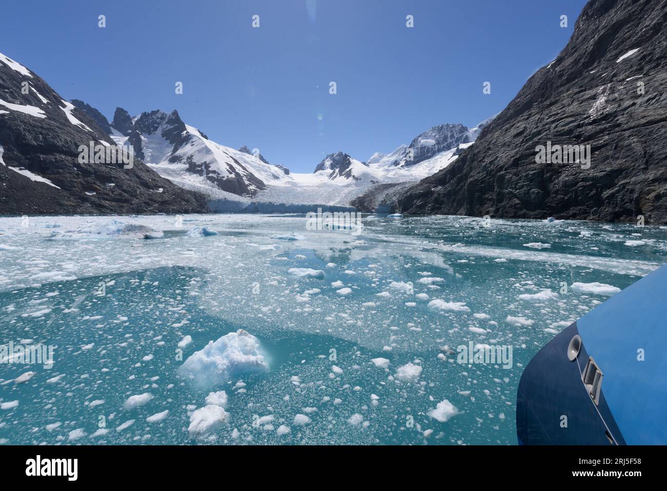 Bow of an expedition ship - floating ice and snow covered mountains at ...