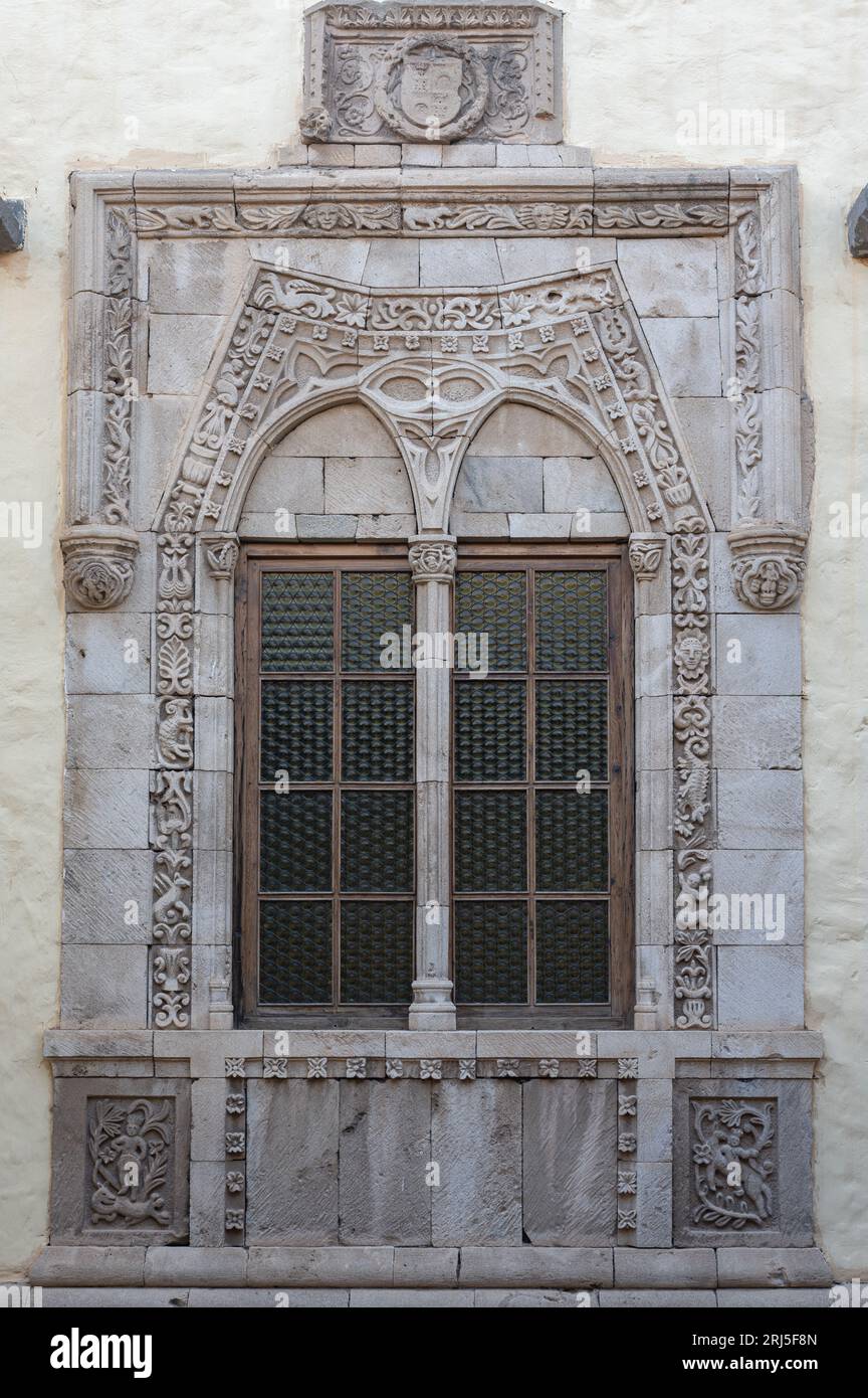 A vertical of a decorated old window of a stone facade Stock Photo - Alamy